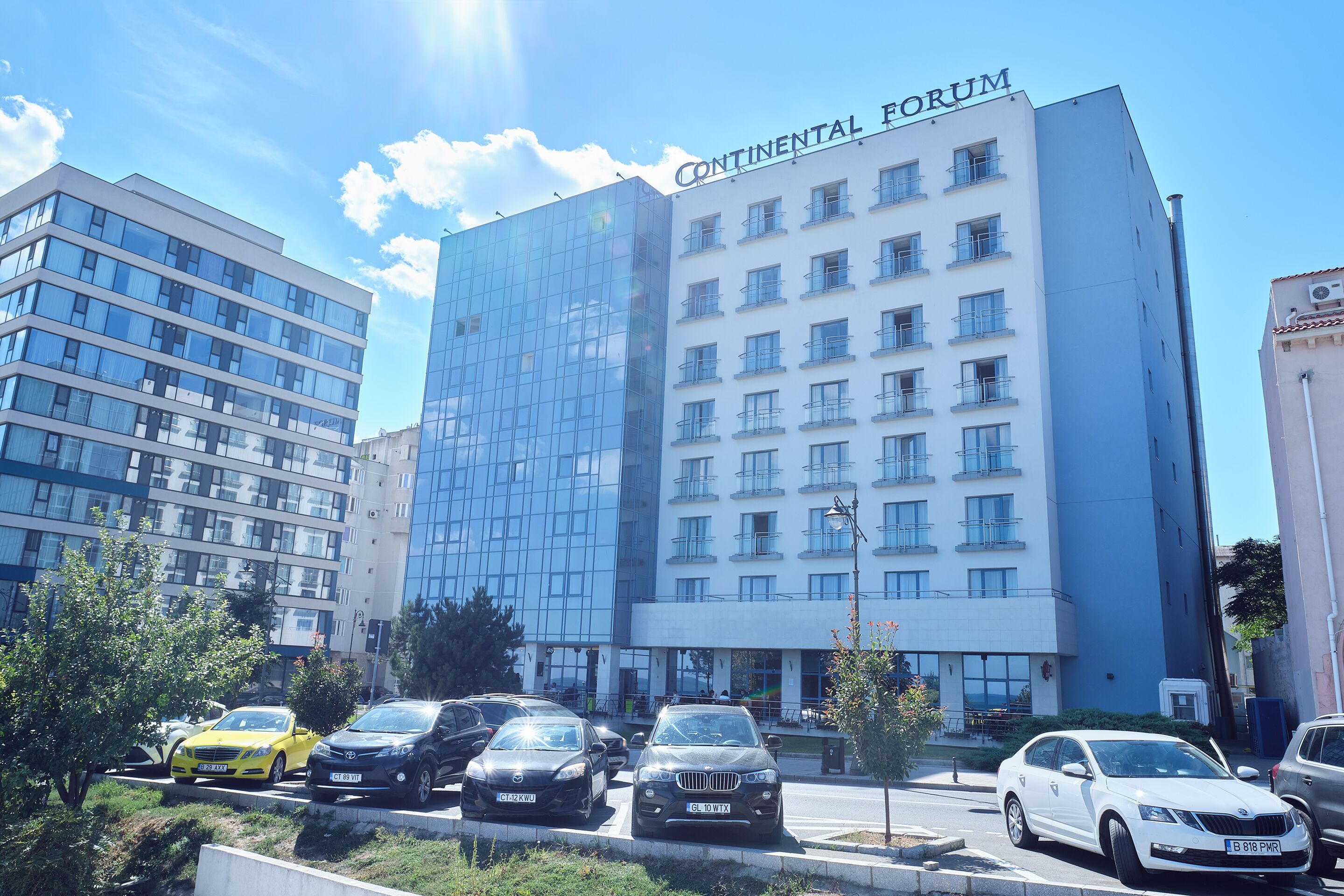 Um hotel de vários andares com fachada de vidro moderna e o nome "Continental Forum" no topo.