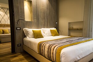 Quarto moderno com uma cama grande, uma mesa de cabeceira e uma luminária fixada na parede.