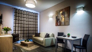 Uma sala de estar moderna com sofá, mesa de centro e mesa de jantar.