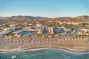 Na praia, espreguiçadeiras, guarda-sóis, prática de vôlei de praia