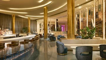 Um lobby moderno com área de bar, assentos e colunas decorativas.