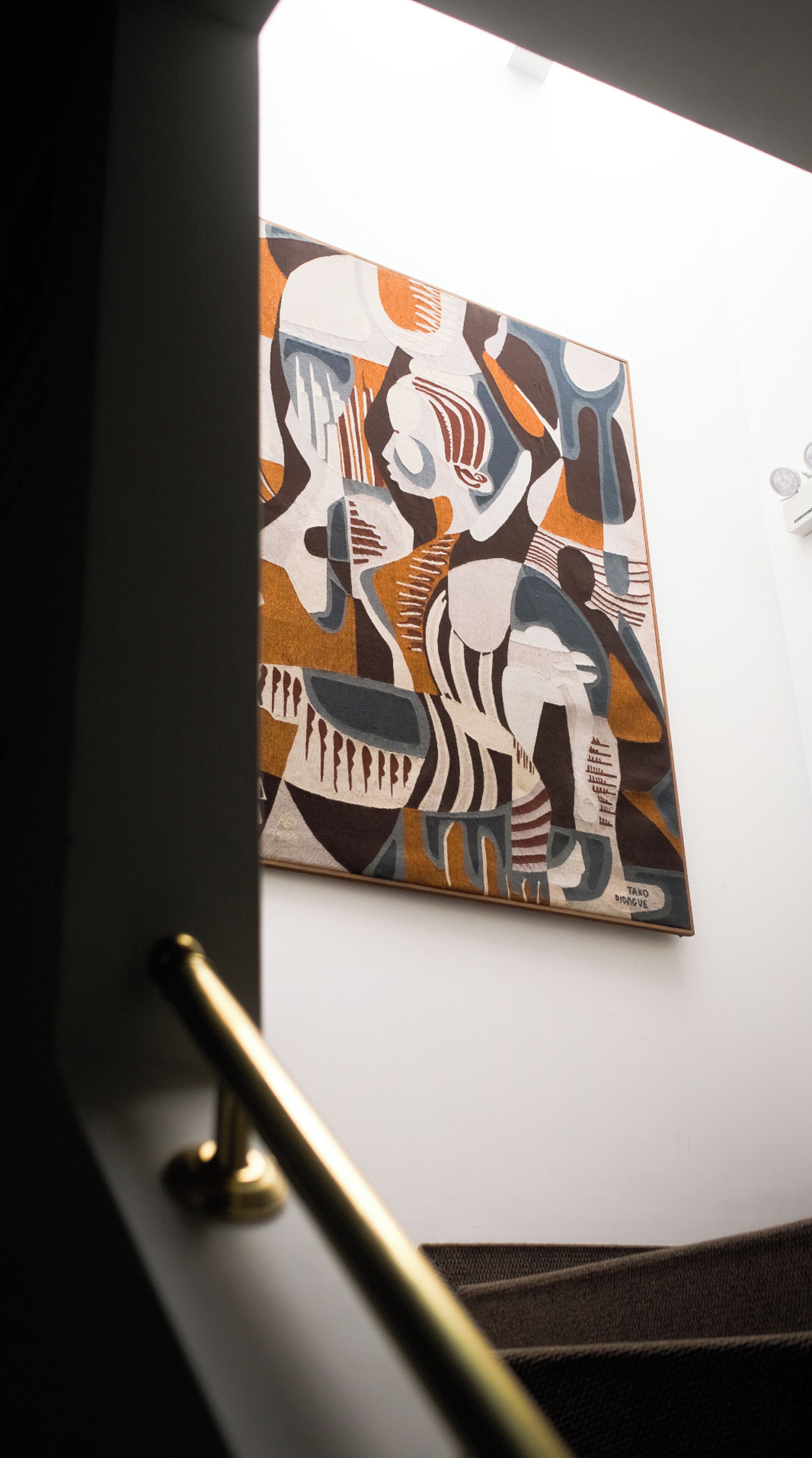 Pintura abstrata emoldurada em uma parede branca.