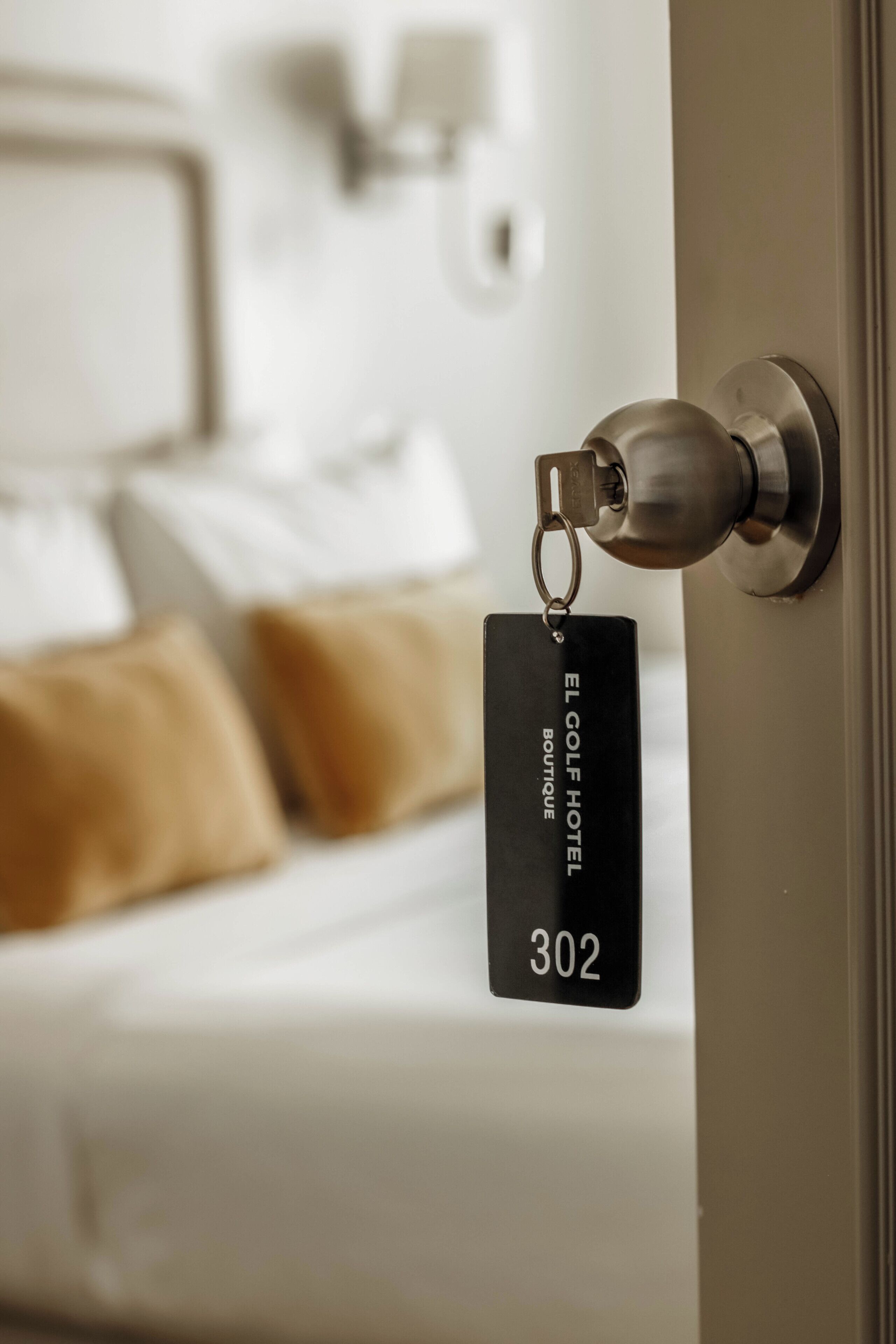 Porta de quarto de hotel com um cartão chave identificado como 'EL GOLF HOTEL BOUTIQUE 302'.