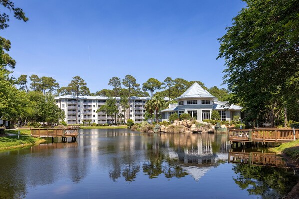 Um hotel com vista para o lago, um gazebo e uma área de piscina.
