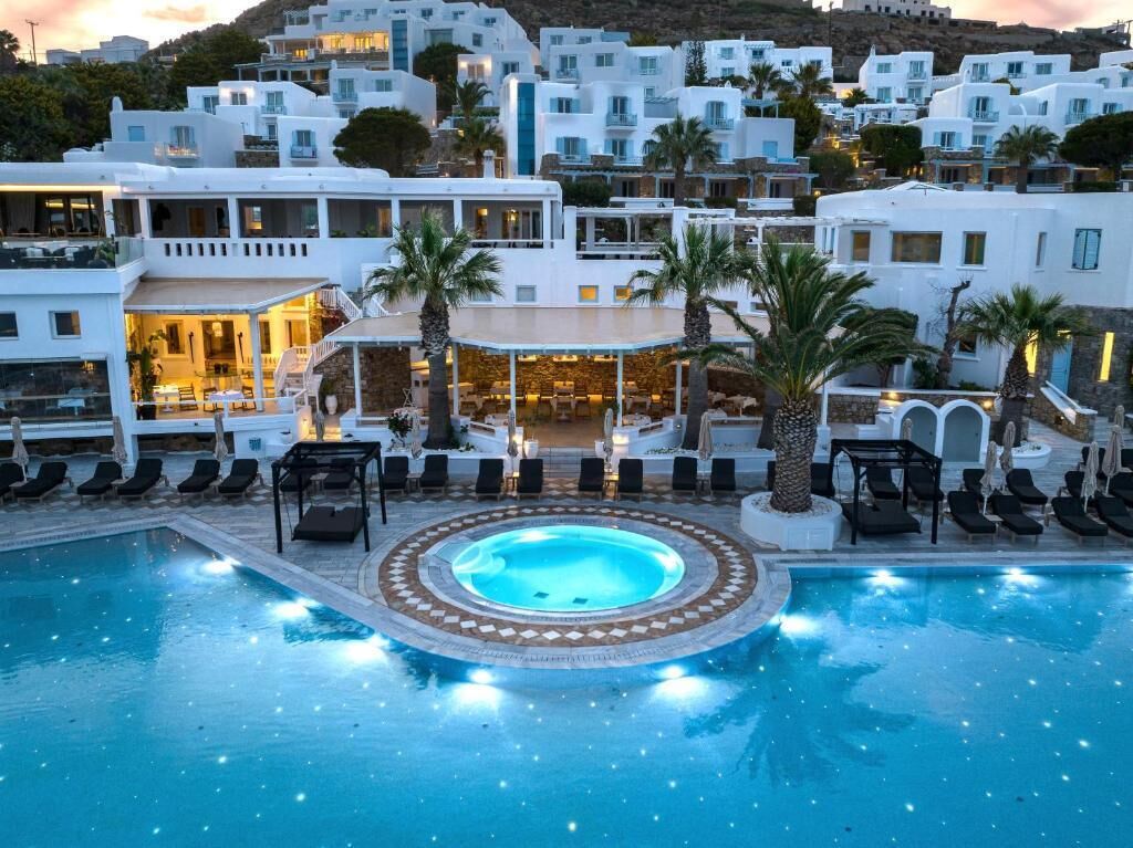 Um hotel com piscina, espreguiçadeiras e terraço solar.