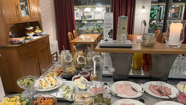 Disposição de buffet com diversos alimentos e acompanhamentos.