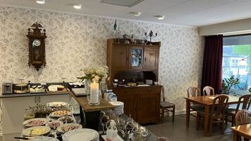 Uma área de refeições com serviço de buffet, um armário de madeira e um relógio na parede.
