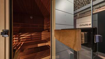 Uma sala de sauna com bancos de madeira e porta de vidro.