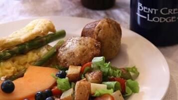 Prato de comida com aspargos, bolacha e salada de tomate e azeitonas.