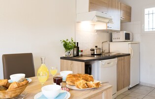 Uma cafeteira/bule, um frigorífico, um micro-ondas