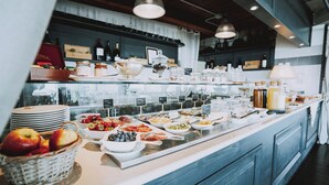Um buffet de café da manhã com diversos alimentos e seleção de vinhos.
