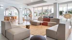 Um interior moderno com área de estar, espaço para refeições e grandes janelas com vista para a cidade.