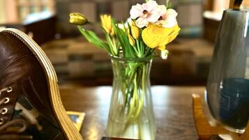 Um livro com o título 'Lodge' sobre uma mesa, com um vaso de flores e um par de sapatos.