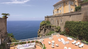 Um hotel com terraço e vista para o mar, com área de estar ao ar livre e vista do oceano.
