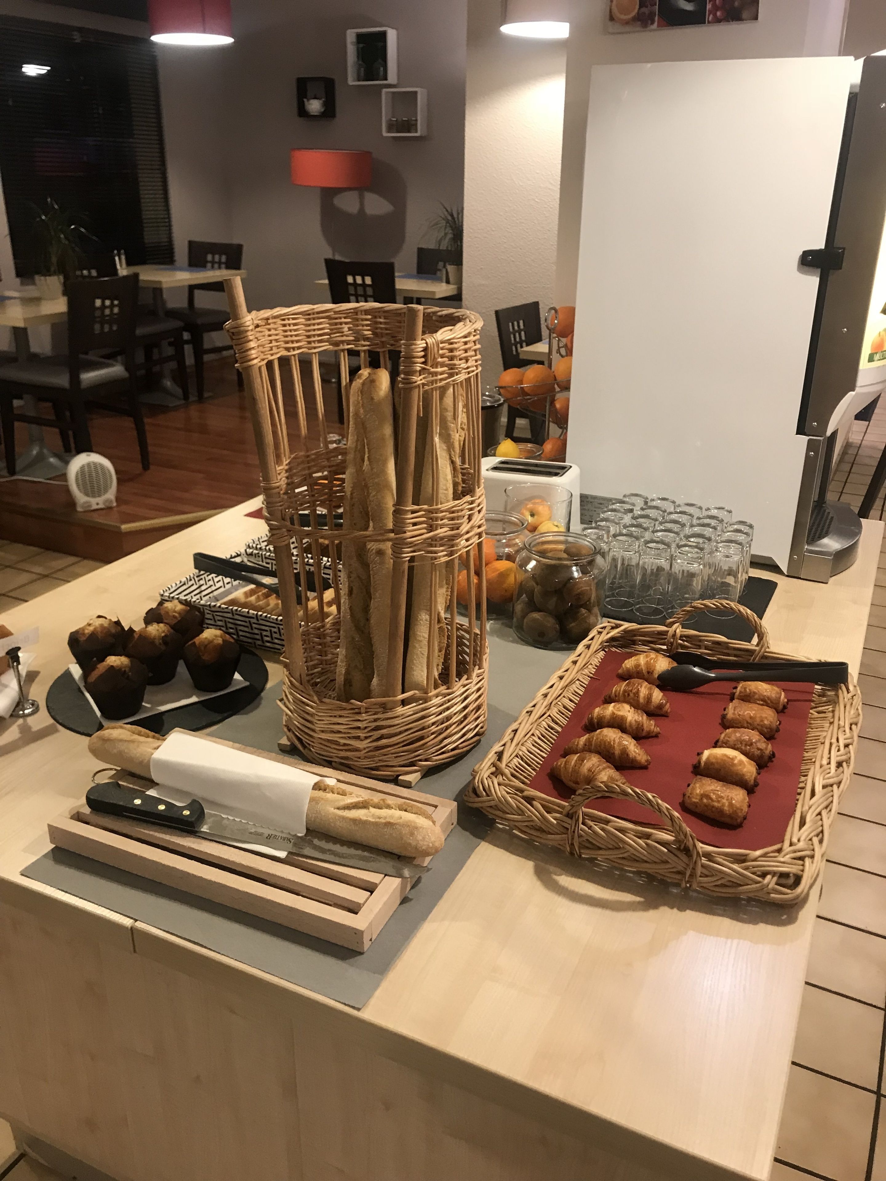 Buffet de café da manhã com pães, doces e frutas.