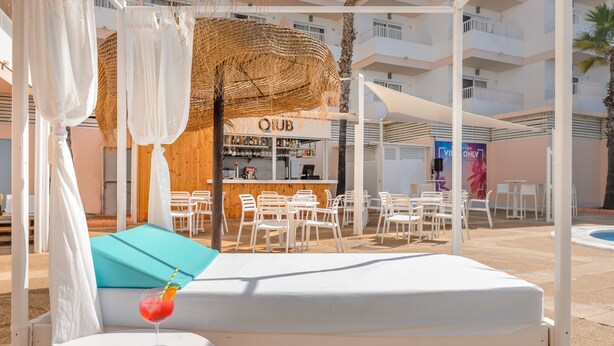 Quarto de hotel com uma cama, um bar e área externa.