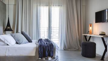 Quarto com uma cama, escrivaninha e televisão.