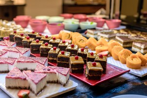 Diversos doces à mostra, incluindo brownies, cheesecakes e pastéis.