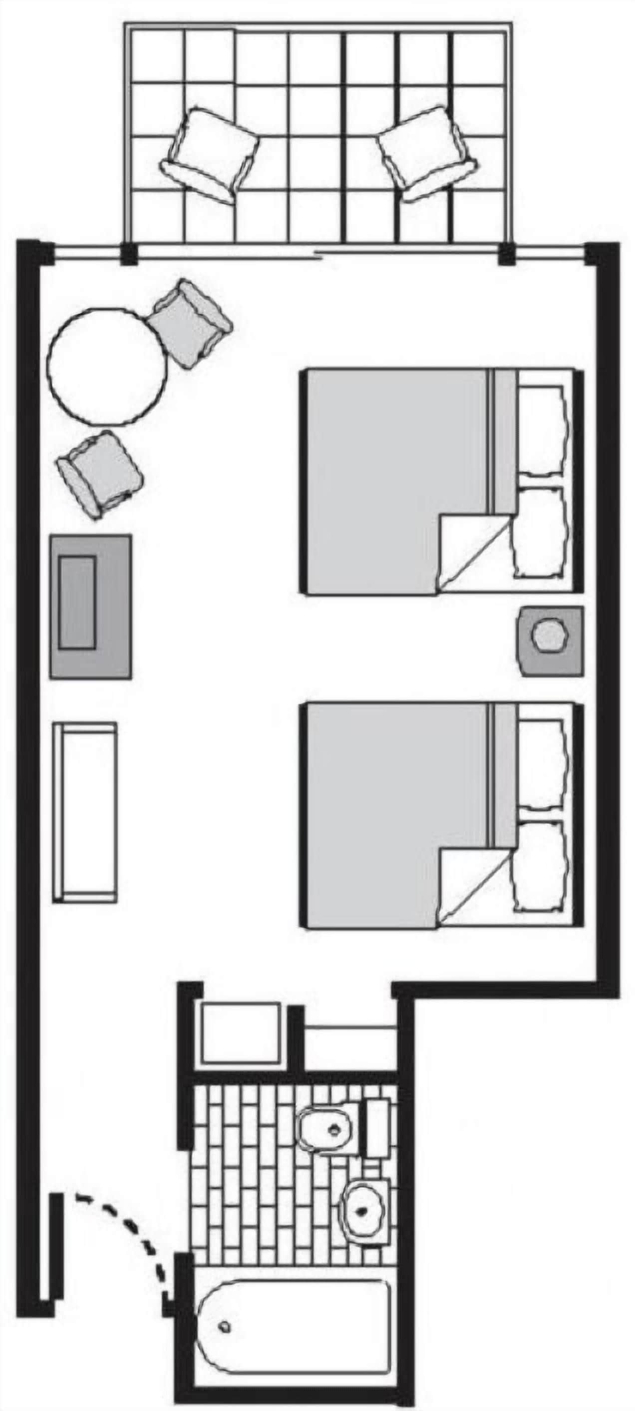 Disposição de quarto de hotel com cama, área de estar e pequena cozinha.