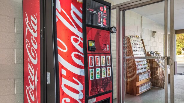 Máquina de vendas automática da Coca-Cola com seleção de bebidas e visor digital.