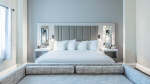 Quarto moderno com cama grande, mesas de cabeceira e cabeceira embutida.