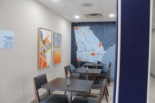 Restaurante com mesas, cadeiras, mapa na parede e aviso indicando horário do café da manhã cortesia.