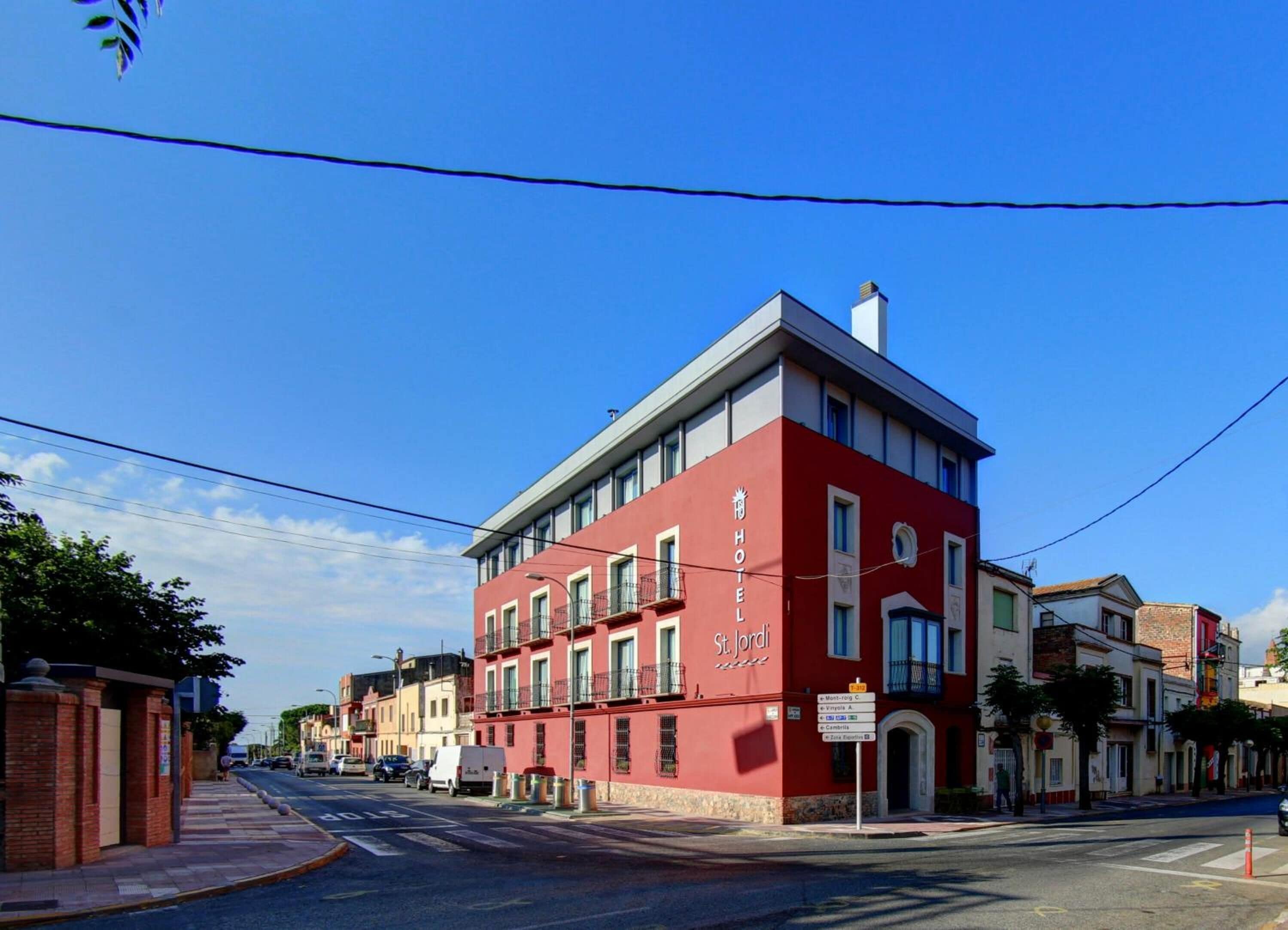 Um hotel vermelho com fachada moderna, situado numa esquina.
