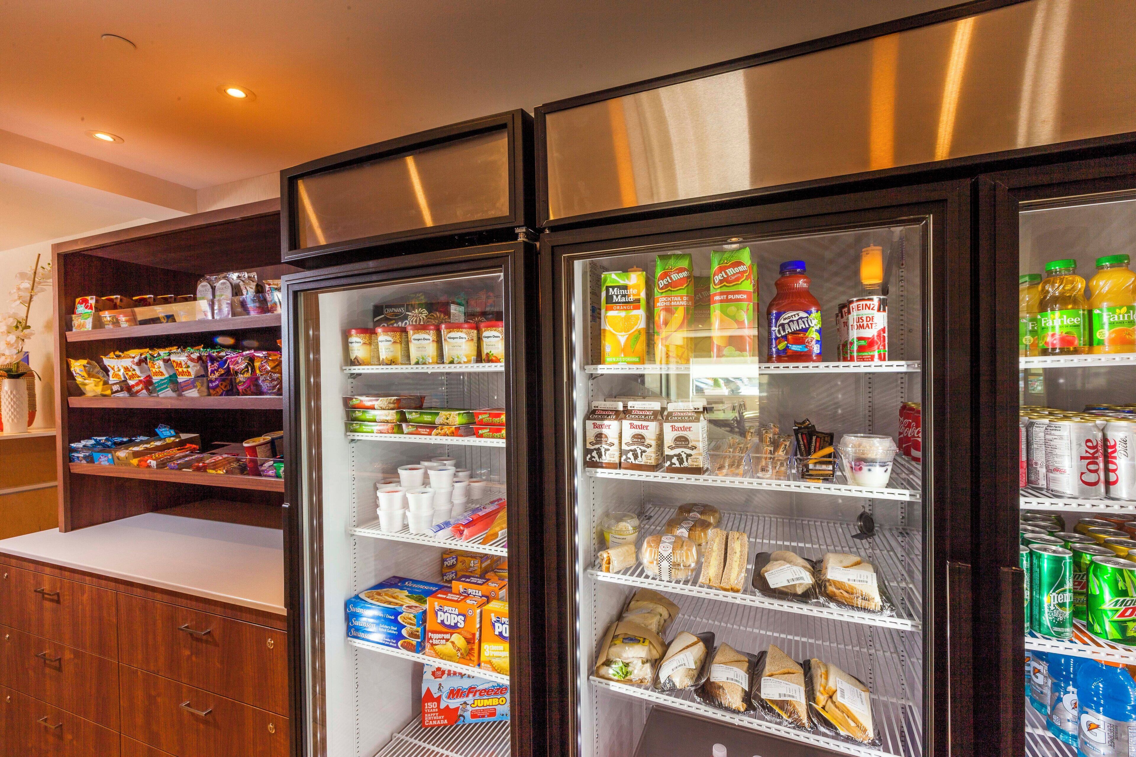 Mini-bar de hotel com diversos alimentos e bebidas.