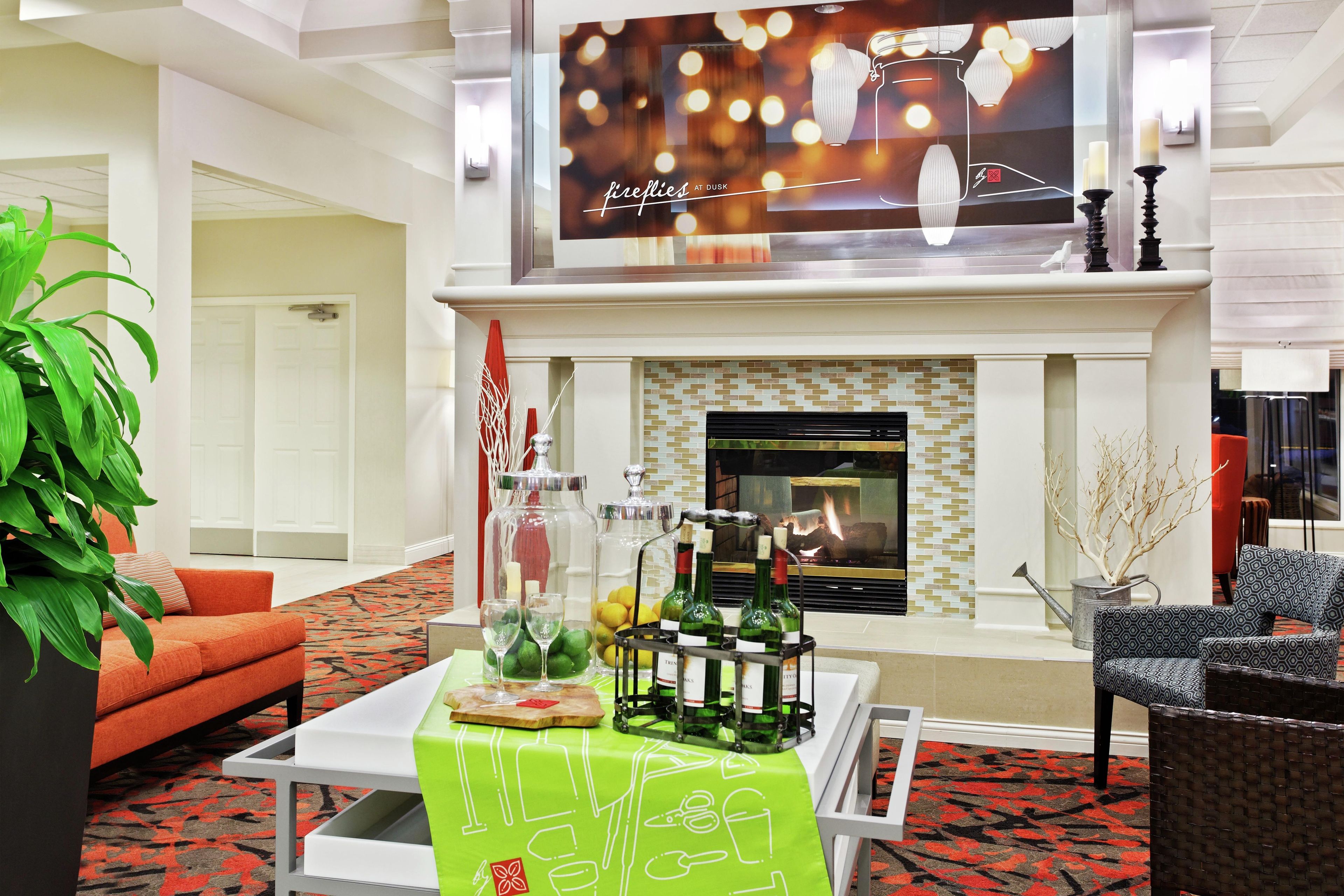Um hall com lareira, área de estar e uma mesa com toalha verde.