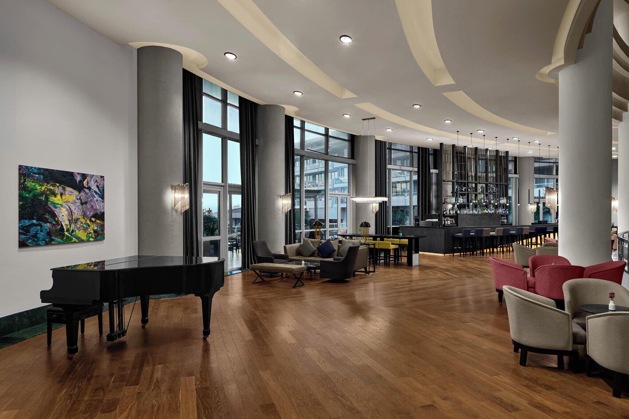 Um hall espaçoso com um piano de cauda, assentos confortáveis, um bar e amplas janelas com vista.
