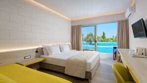 Quarto de hotel com uma cama, uma secretária, uma cadeira e vista para uma piscina.