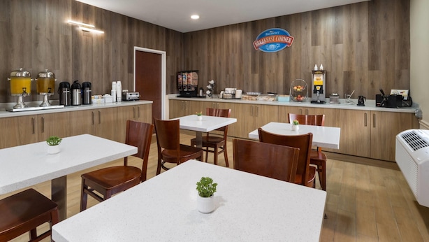 Um canto de café da manhã com paredes de painel de madeira, uma placa indicando 'Breakfast Corner' e um espaço com diversos equipamentos para café.