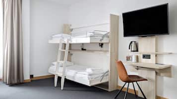 Uma cama beliche com uma escrivaninha e uma televisão num quarto de hotel.