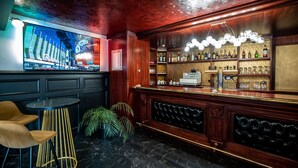 Uma área de bar com balcão, banquetas e uma seleção de garrafas.