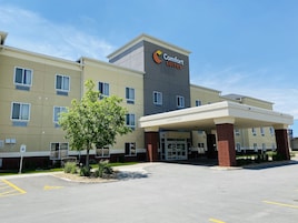 Hotel Comfort Suites com entrada acessível, estacionamento e sinalização de vagas para deficientes.