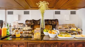Disposição de buffet com diversos alimentos e bebidas.