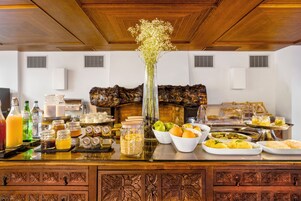 Disposição de buffet com diversos alimentos e bebidas.