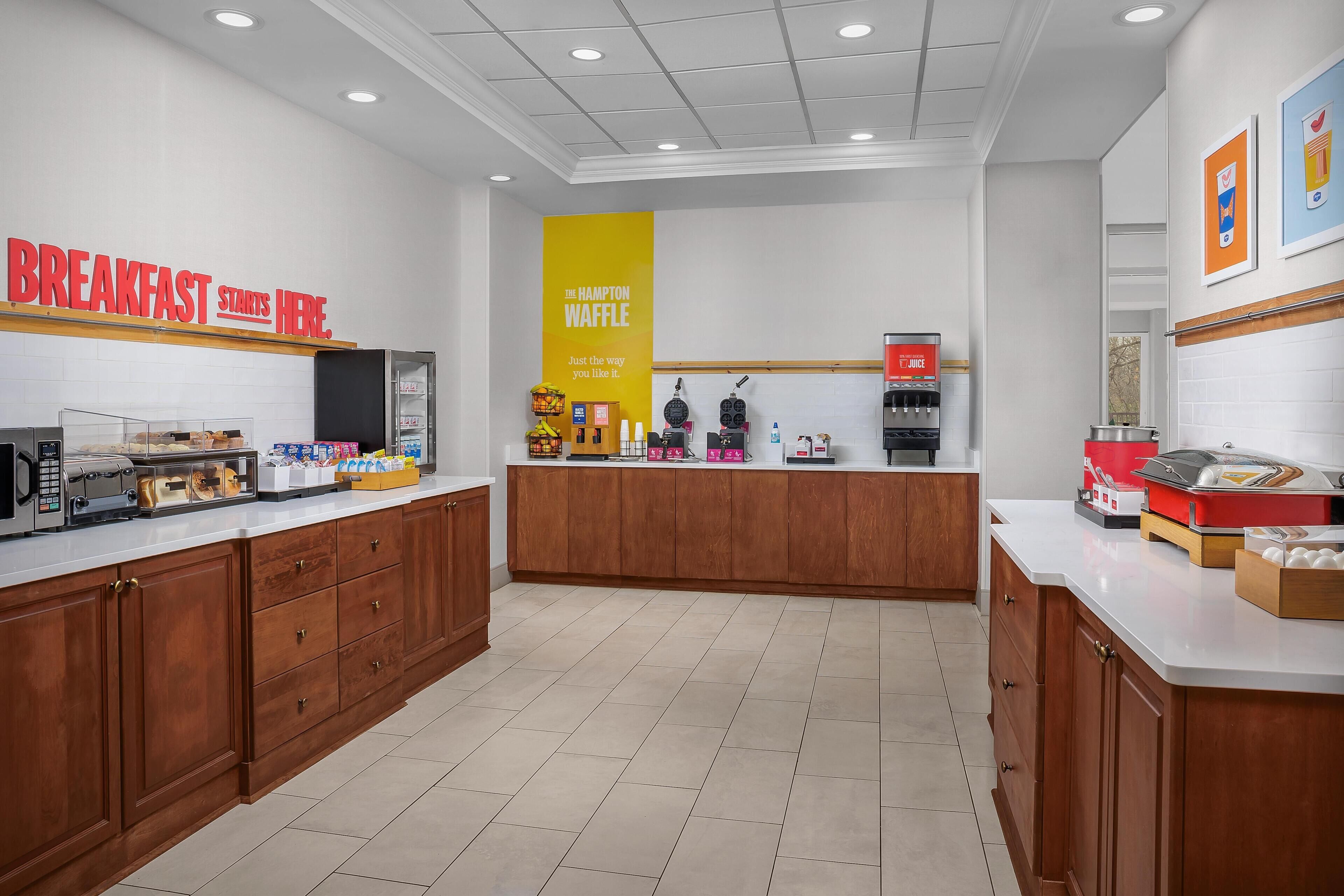 Uma cozinha moderna com balcão de café da manhã, estação de waffles e diversos eletrodomésticos.