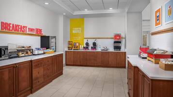 Uma cozinha moderna com balcão de café da manhã, estação de waffles e diversos eletrodomésticos.