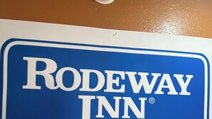 Placa da Rodeway Inn, parte da rede Choice Hotels, com uma tomada elétrica visível logo abaixo.