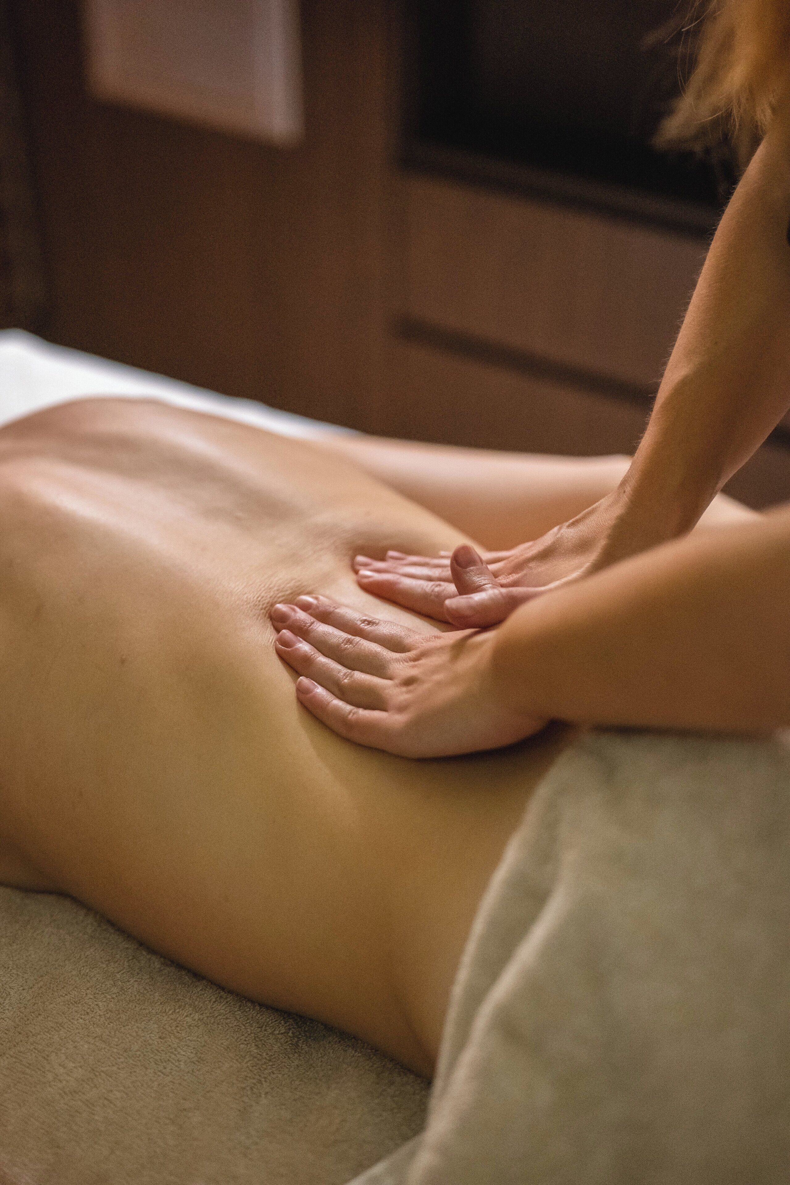 Uma pessoa recebendo massagem em uma maca.