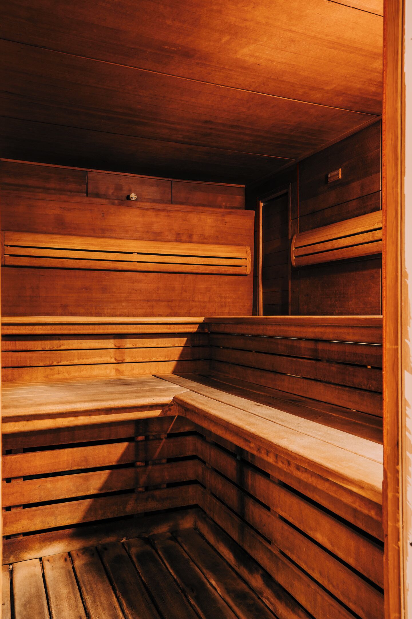 Uma sauna com bancos de madeira e teto inclinado.