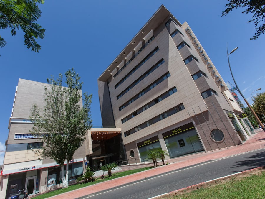 Um edifício moderno com vários andares, uma entrada destacada e uma placa visível com o nome 'IberCaja'.