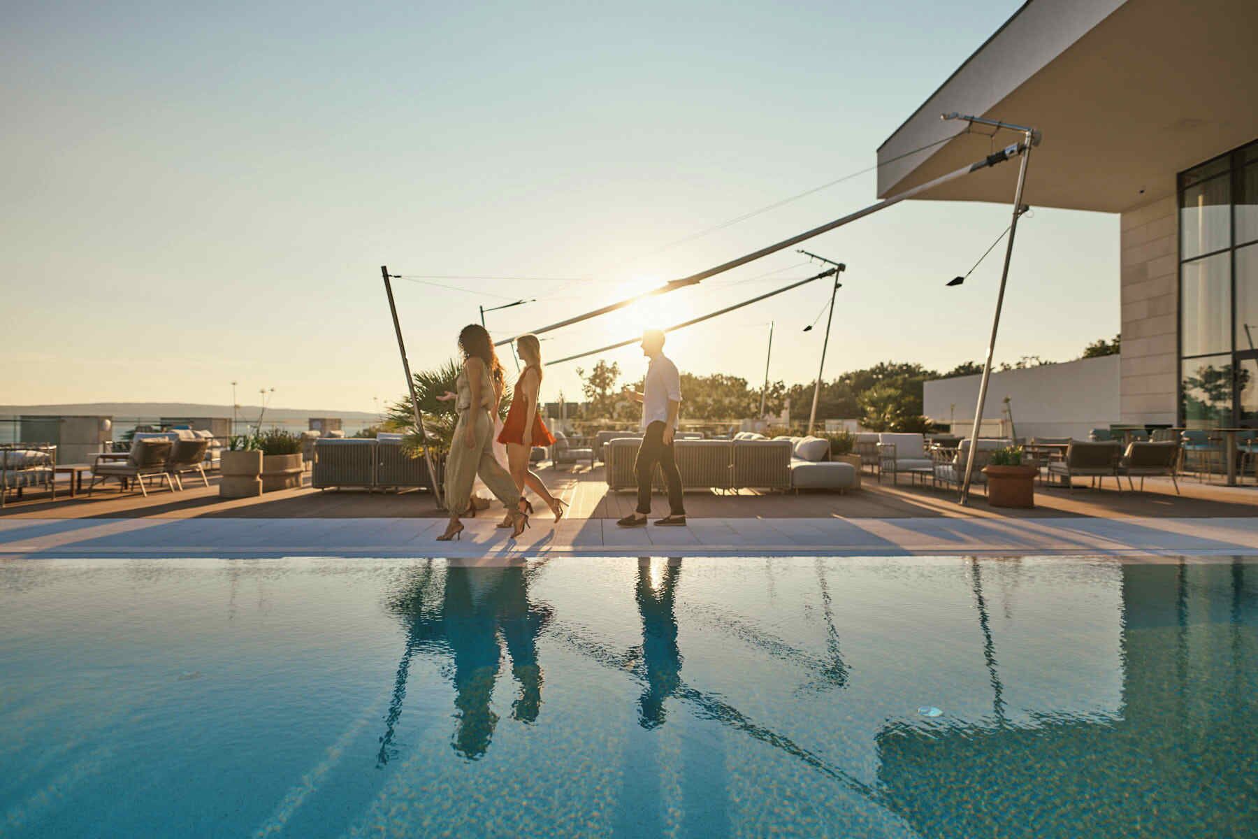 Uma área de piscina no terraço, com espreguiçadeiras e vista ampla do céu.