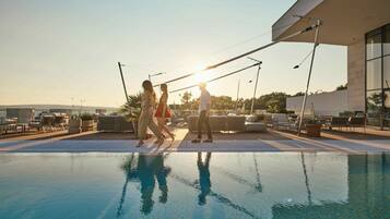 Uma área de piscina no terraço, com espreguiçadeiras e vista ampla do céu.