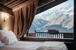 Quarto com vista para montanhas cobertas de neve.