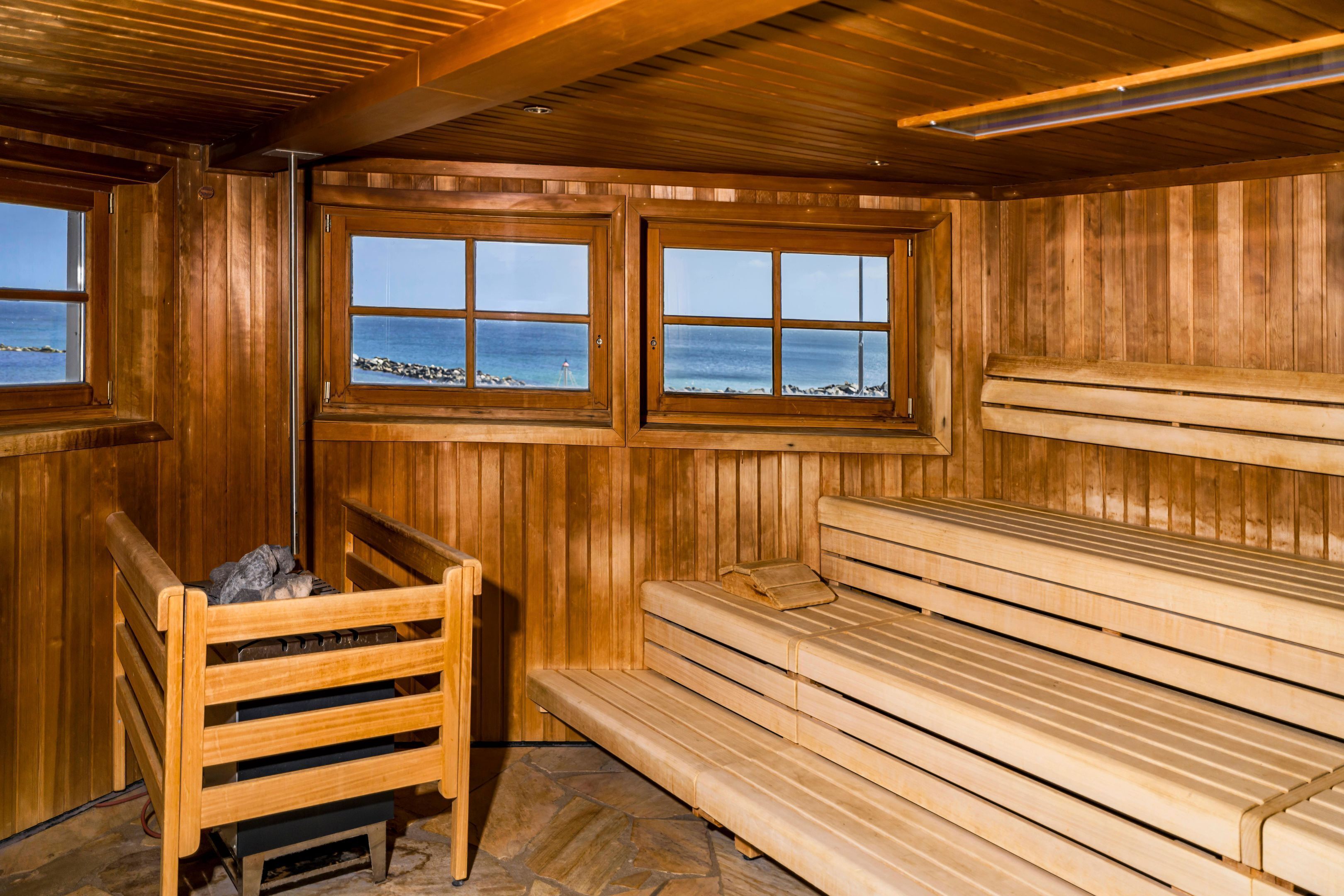 Uma sauna de madeira com bancos e um assento.