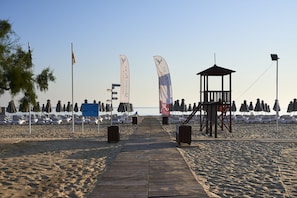 Na praia, espreguiçadeiras, guarda-sóis de praia, bares na praia