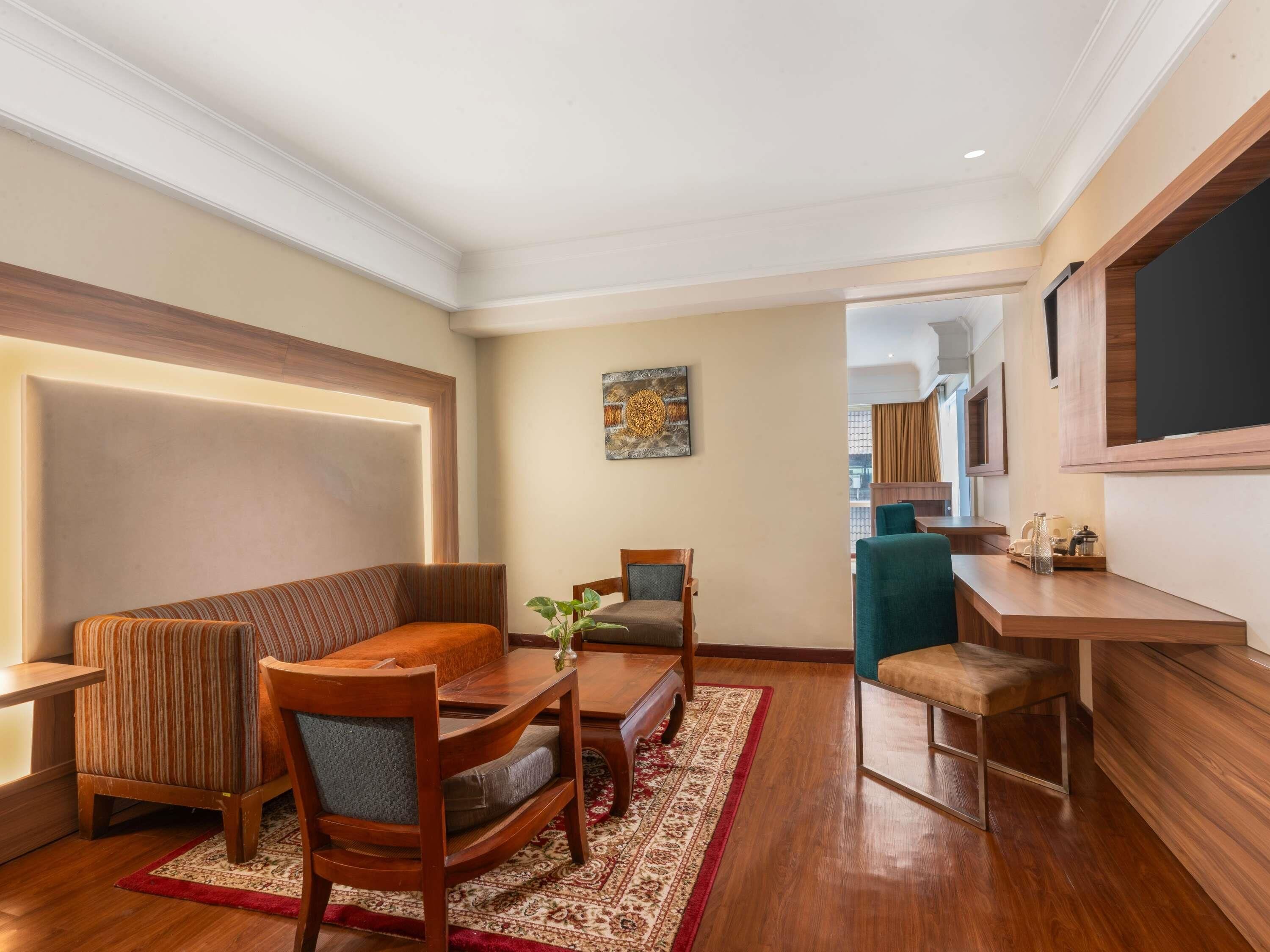 Uma sala de estar moderna com sofá, poltronas, mesa de centro e televisão.