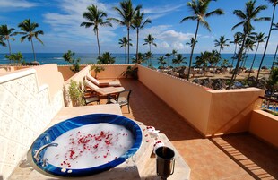 Terraço no telhado com hidromassagem, espreguiçadeiras e vista para a praia e oceano.